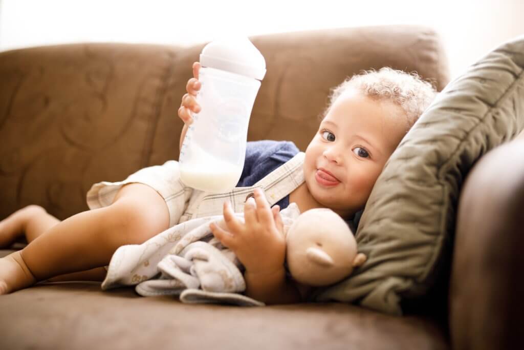 Baby holding milk bottle - PAL - Parenting Assistance Line